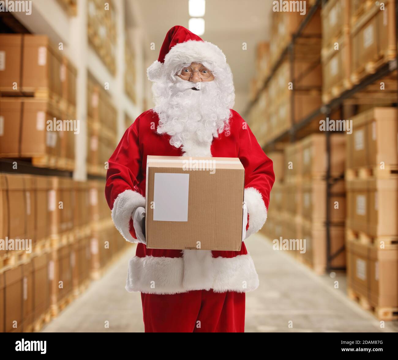 Santa claus holding a cardboard box inside a warehouse Stock Photo - Alamy