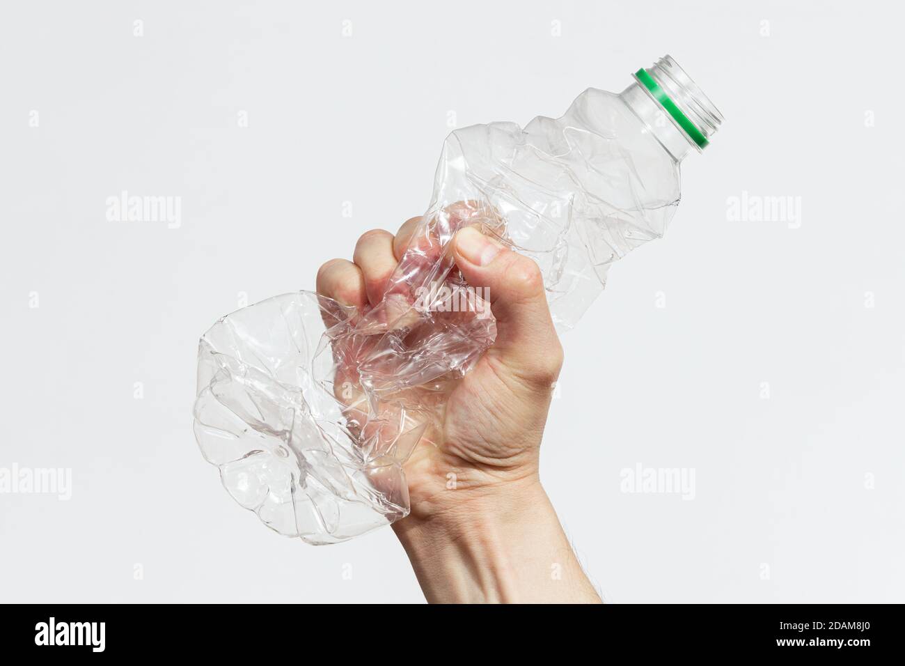 Man smashing a plastic bottle with his hand on white background Stock ...