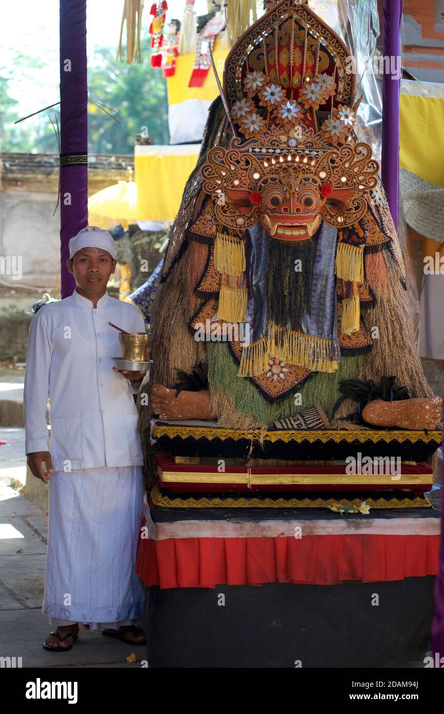 Balinese Hindu temple priest in traditional white attire standing next ...