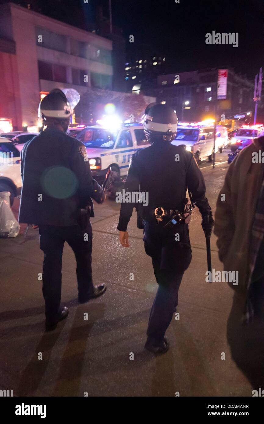 Rear View of Two Heavily Geared NYPD Officers walking with Helmets and ...