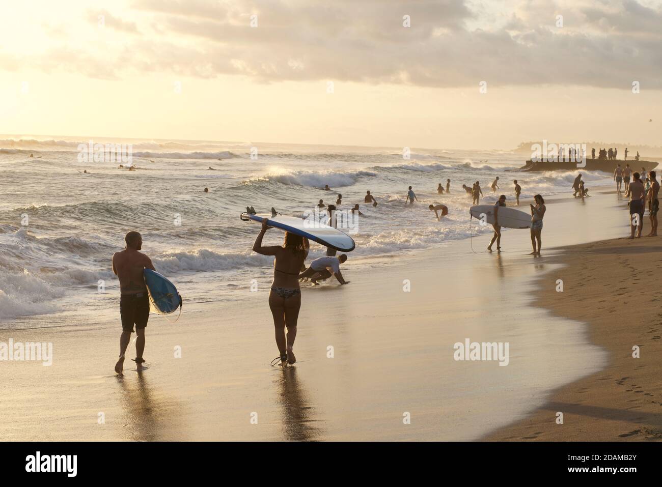 Beachgoers and surfers on Nelayan Beach at sunset, North of Kuta, Bali ...