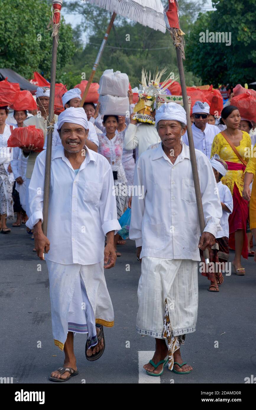 Balinese men in traditional white attire, attending Galungan ...