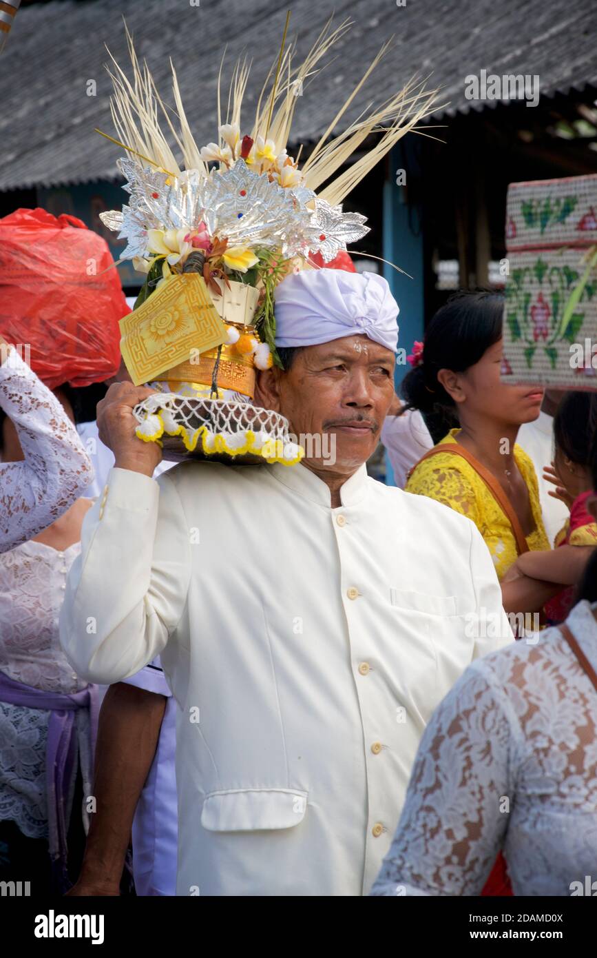 Balinese man in traditional white attire, attending Galungan ...