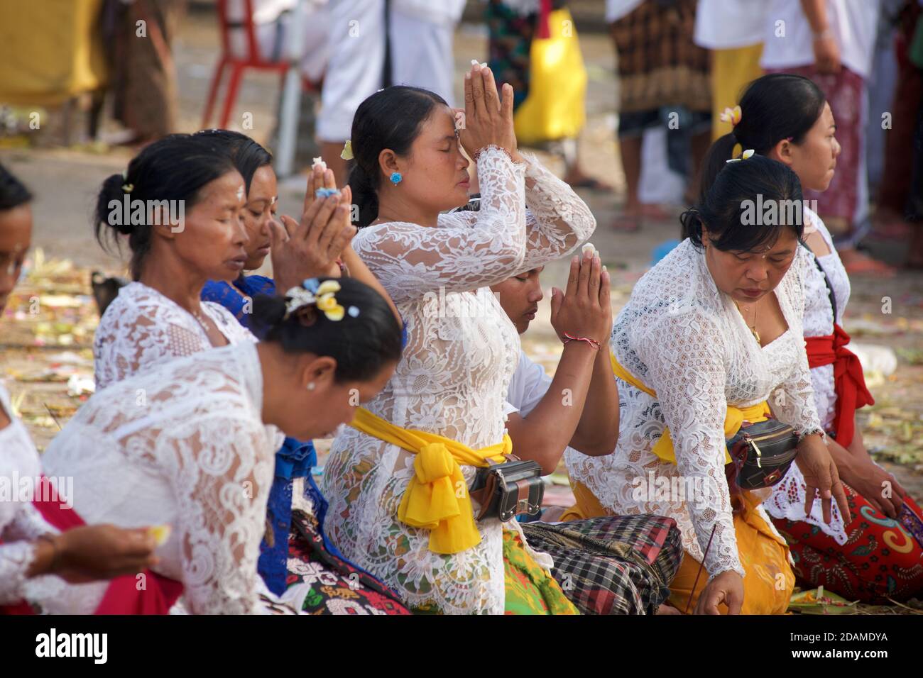 Balinese women praying and making offerings at Sakenan temple, Bali ...
