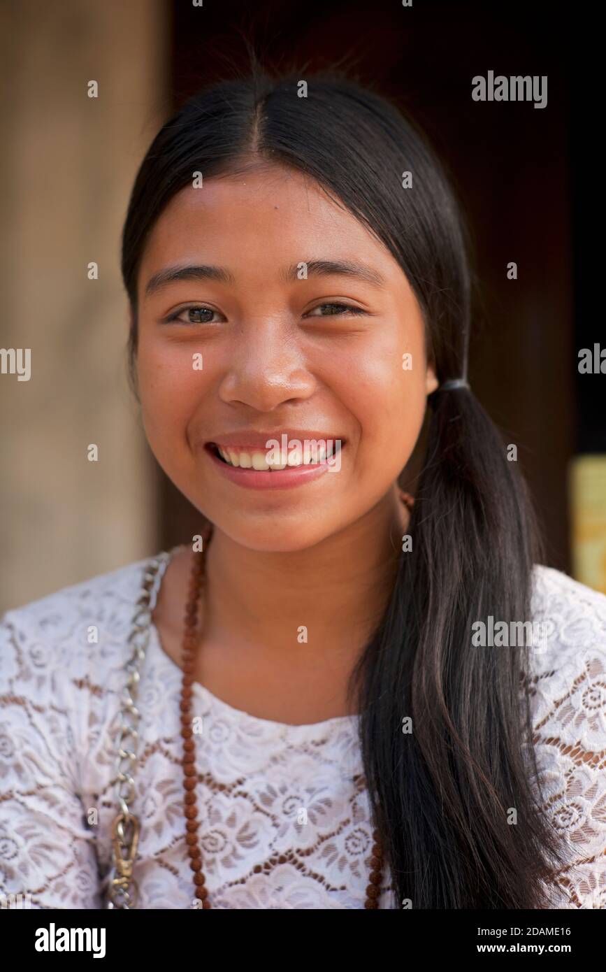 Portrait of a young Balinese woman in festive dress at Sakenan temple ...