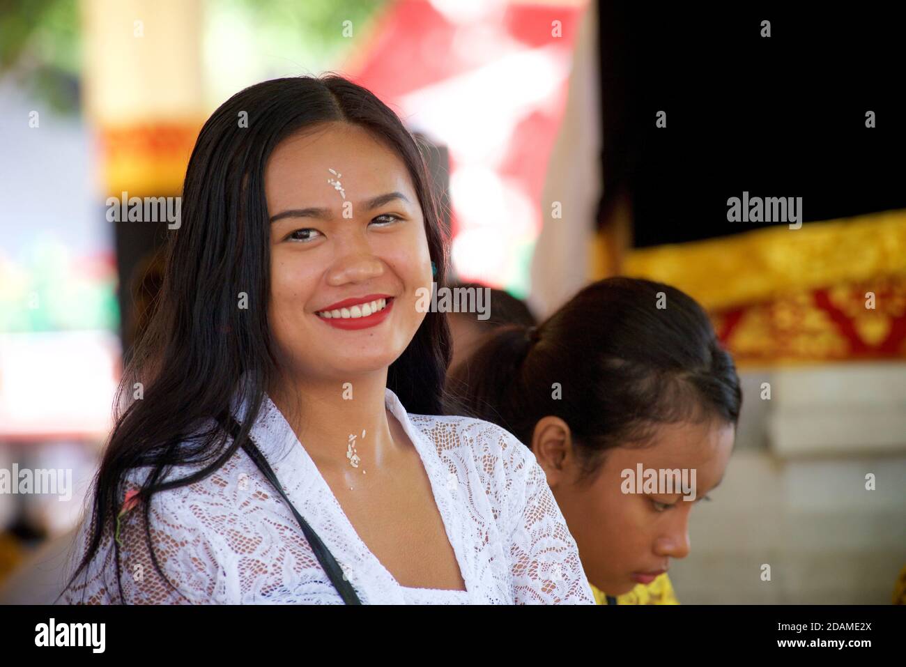 Portrait of a smiling Balinese woman attending a Hindu ceremony at ...