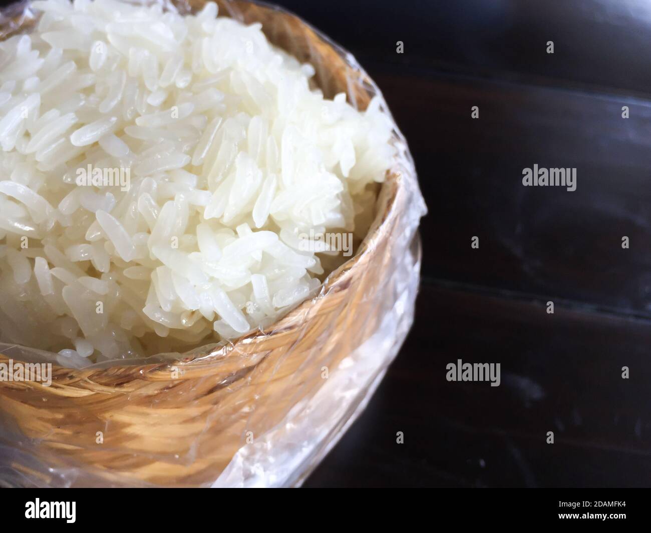 closeup sticky rice in bamboo container on wooden black background ...