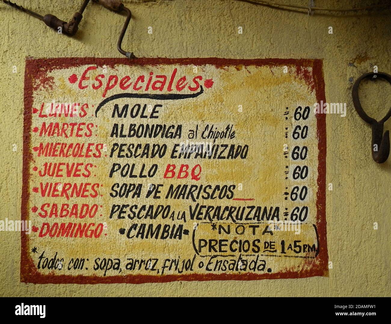 A menu painted on a yellow stucco well displays the daily specials ...