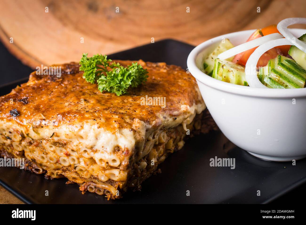 Pastitsio Greak style pasta with cheese on top served with salad Stock ...
