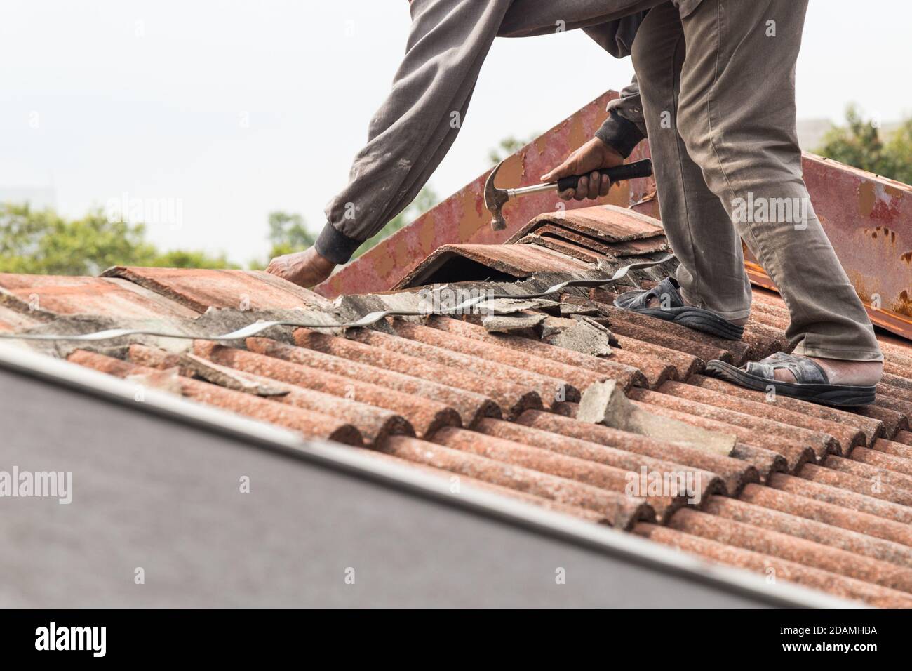 Asian worker replacing roof tiles of old residential building Stock ...