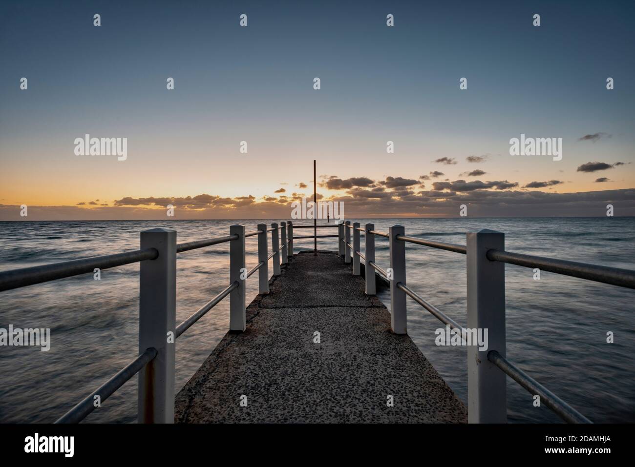 Looking out over a pier against the ocean, a dusk horizon sky Stock ...