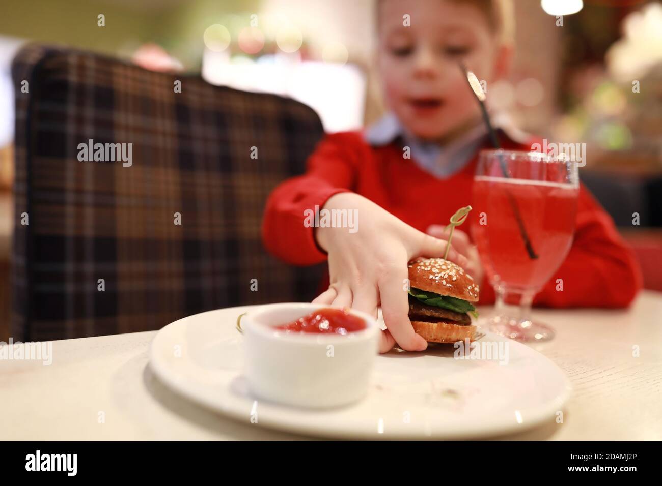Child takes mini burger in a restaurant Stock Photo - Alamy