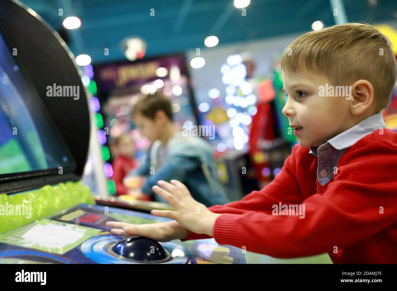 Kids playing arcade game in amusement park Stock Photo - Alamy