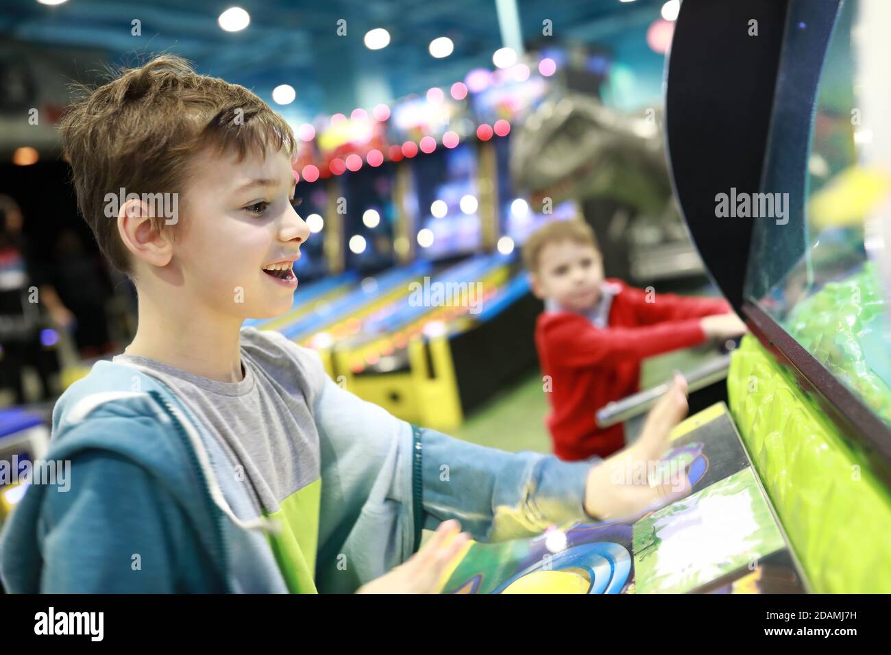 Boys playing arcade game in amusement park Stock Photo - Alamy