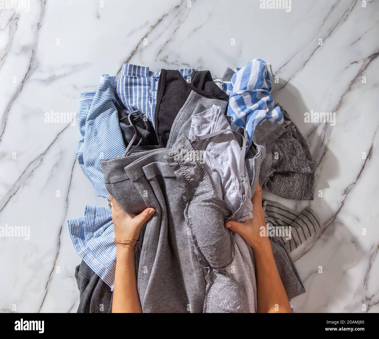 Woman hands putting stack of clean clothes for neatly tidying up and ...