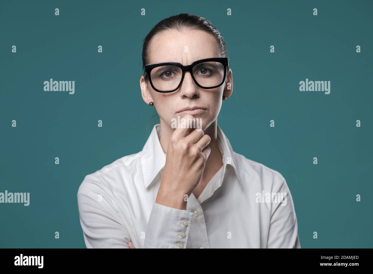 Worried pensive woman thinking with hand on chin, she is making a ...