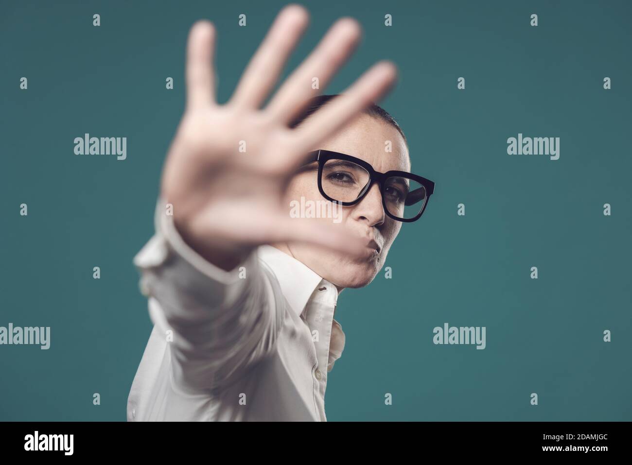 Confident woman putting her hand forward and making a stop gesture ...