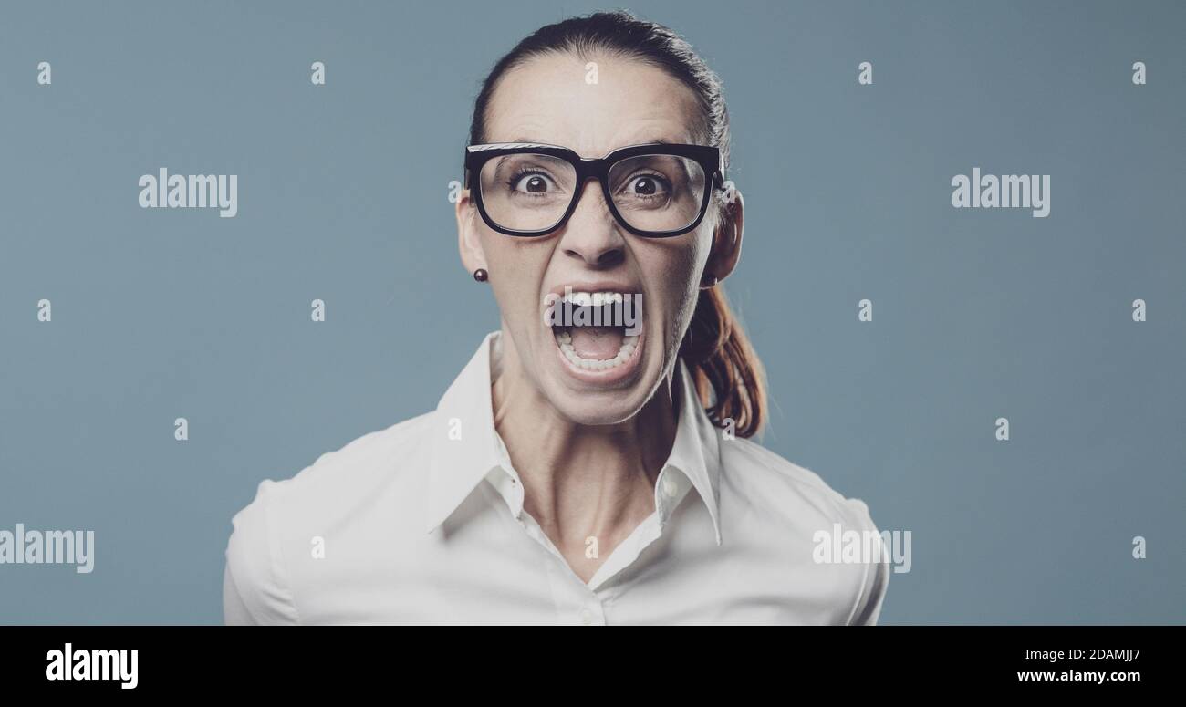 Aggressive angry woman shouting at camera, she is feeling furious and ...