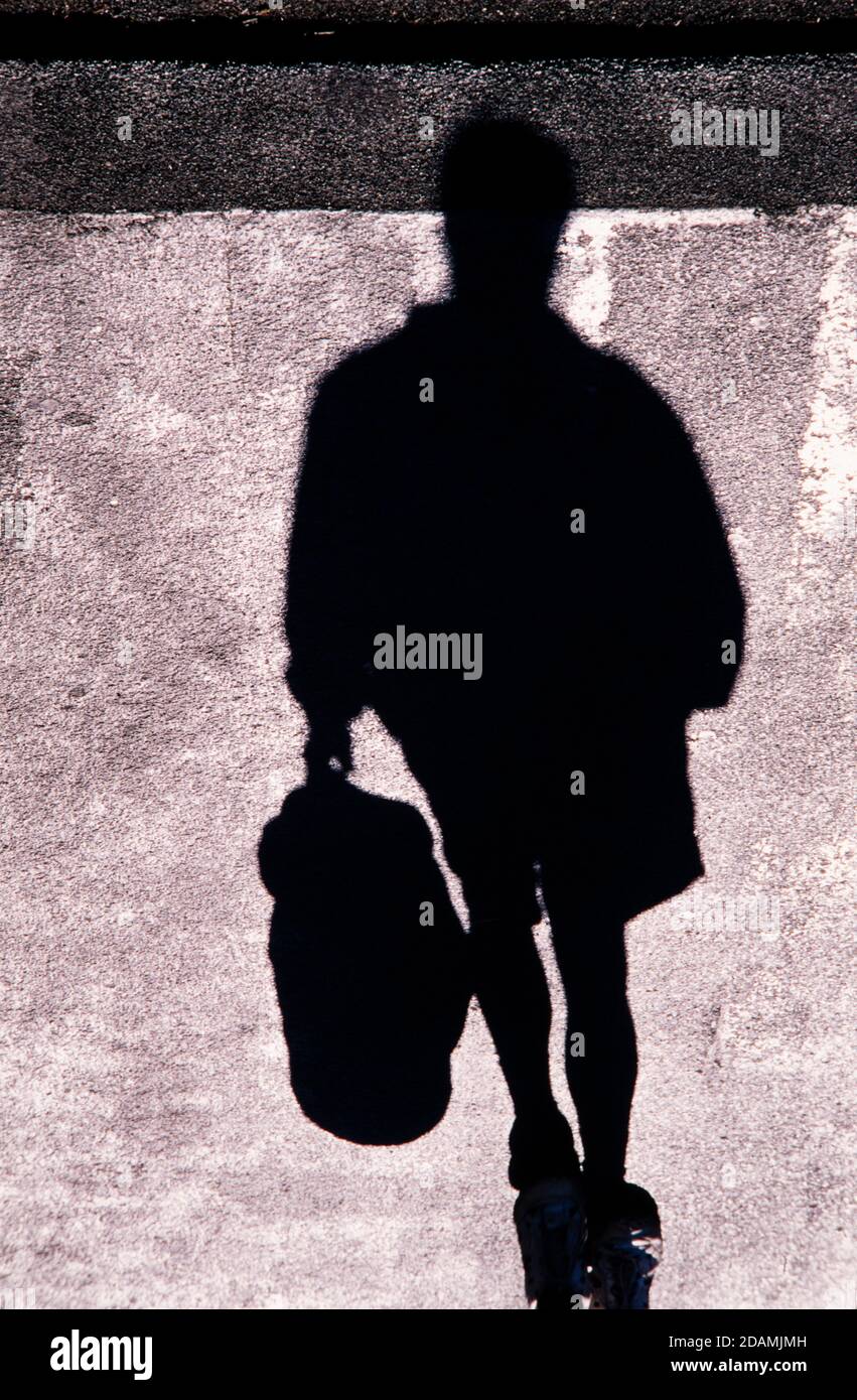 Pedestrian shadows on a blacktop road. A shadow is a dark (real image ...