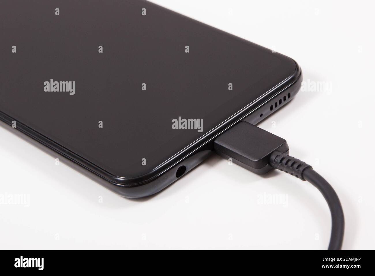 Plug of charger connected to mobile phone. Smartphone charging. White ...