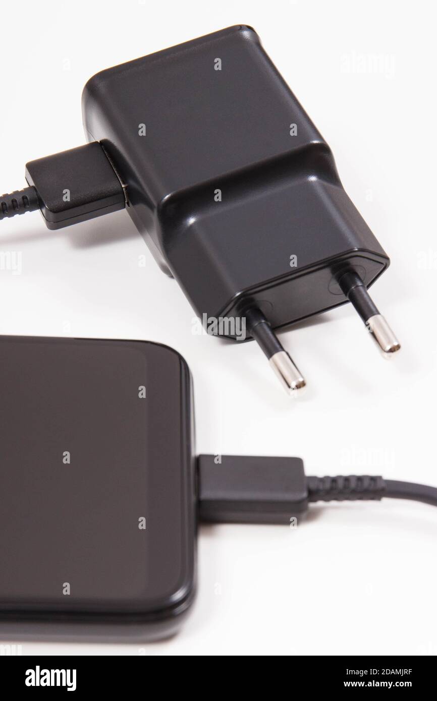 Smartphone with connected plug of charger. Telephone charging. White ...