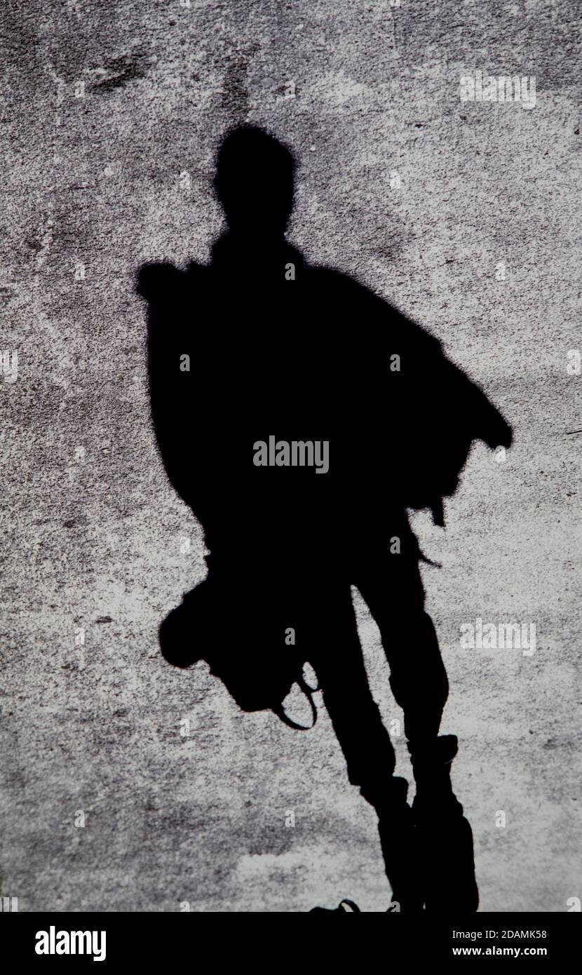 Pedestrian shadows on a blacktop road. A shadow is a dark (real image ...