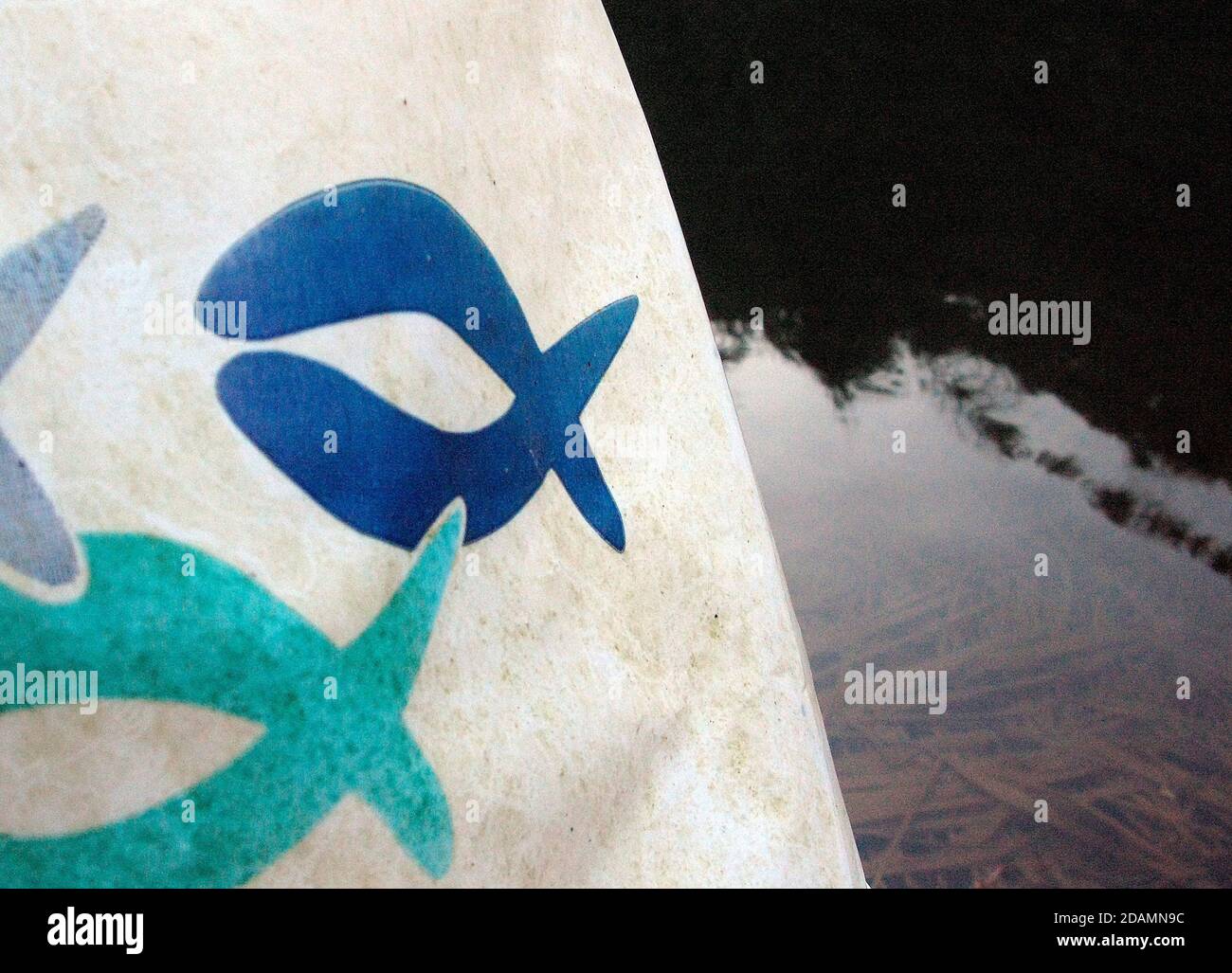 green and blue fish symbols on a boat in the water Stock Photo - Alamy