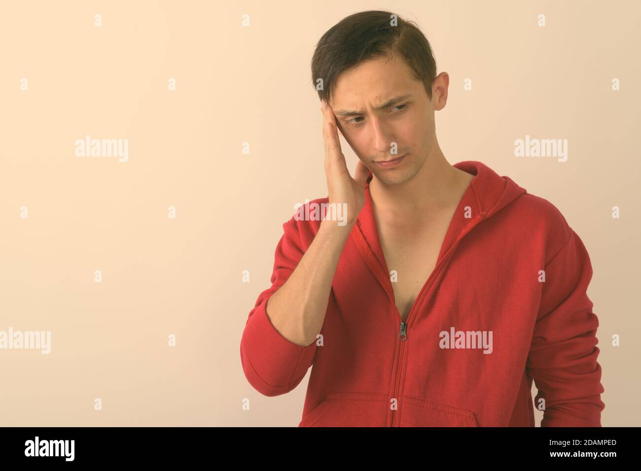 Close up of stressed young man thinking while having headache against white background Stock ...