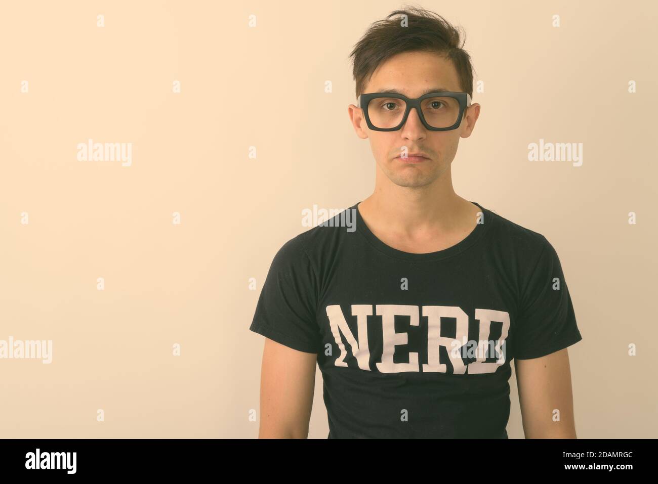 Close up of young nerd man wearing eyeglasses against white background ...