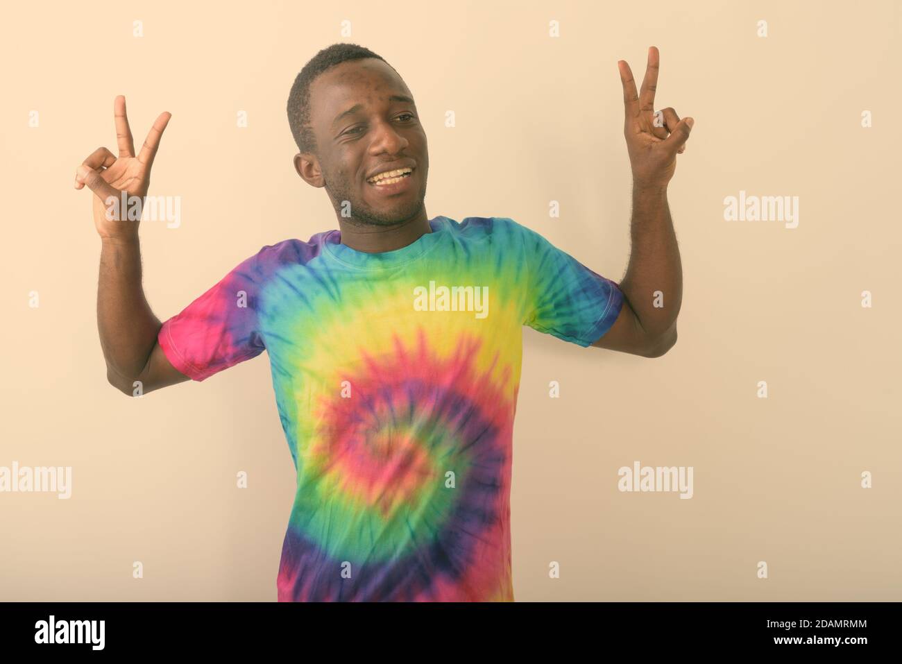 Studio shot of young black African man looking happy and making peace ...