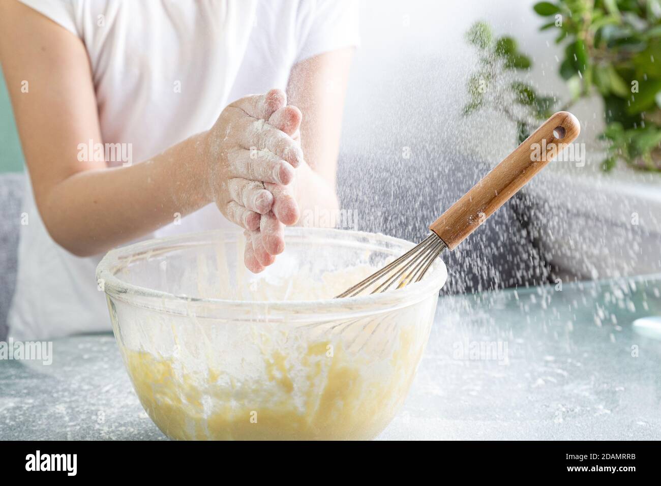 A close-up of the upper body of a child claps its hands over a bowl of ...