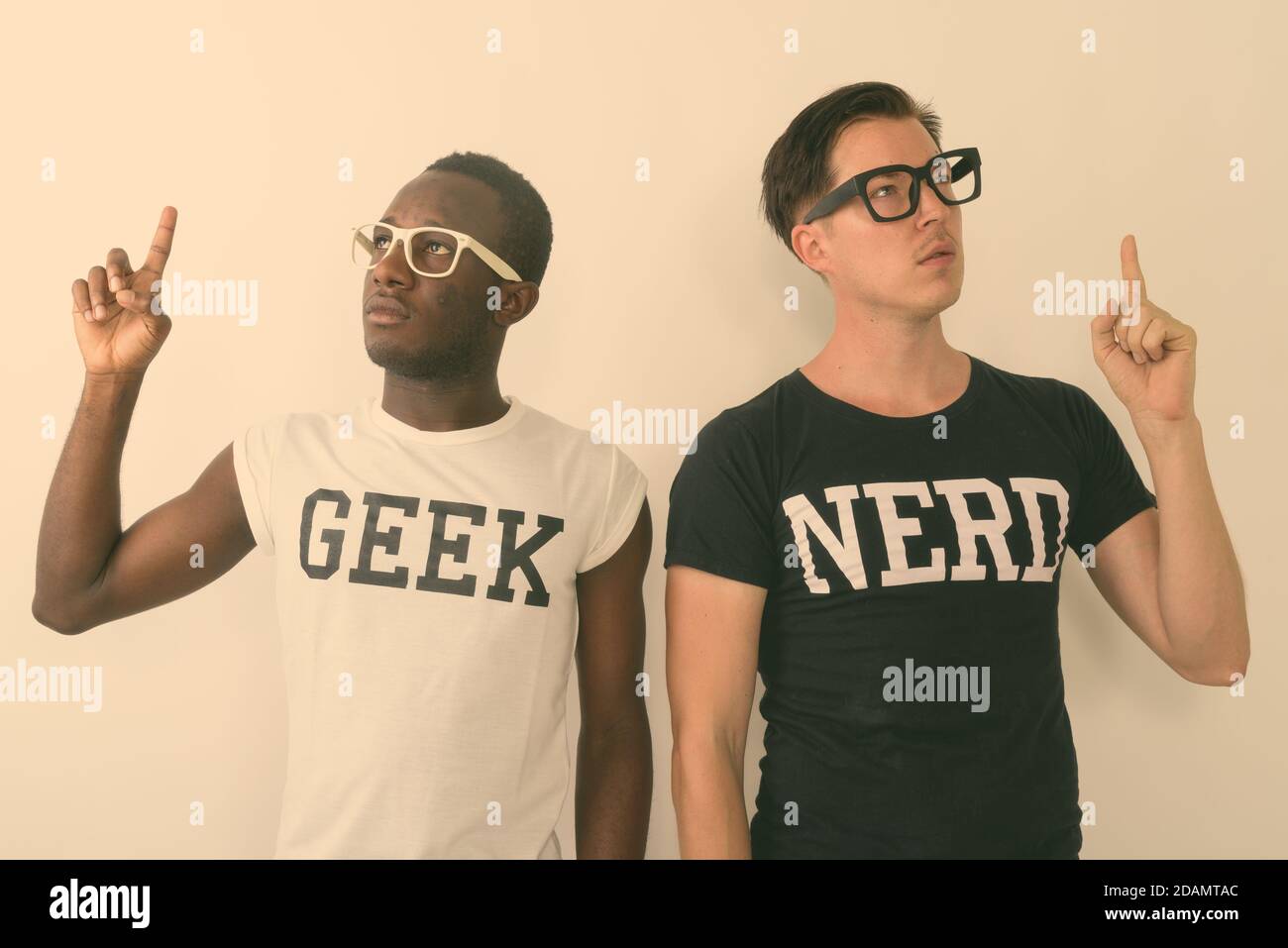 Studio shot of young black African Geek man with European Nerd man ...
