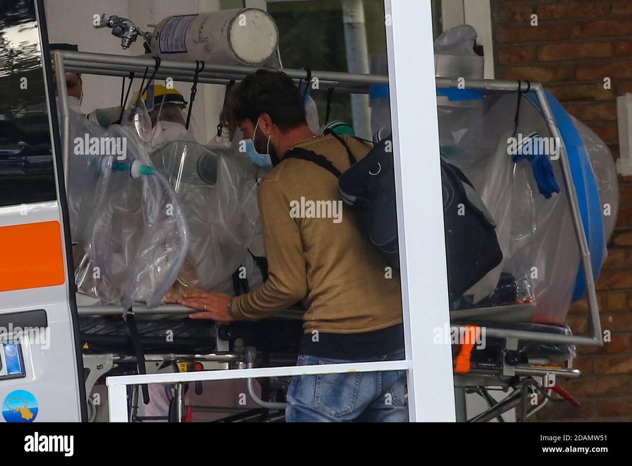 People greet a family member inside a biological isolation chamber. The ...