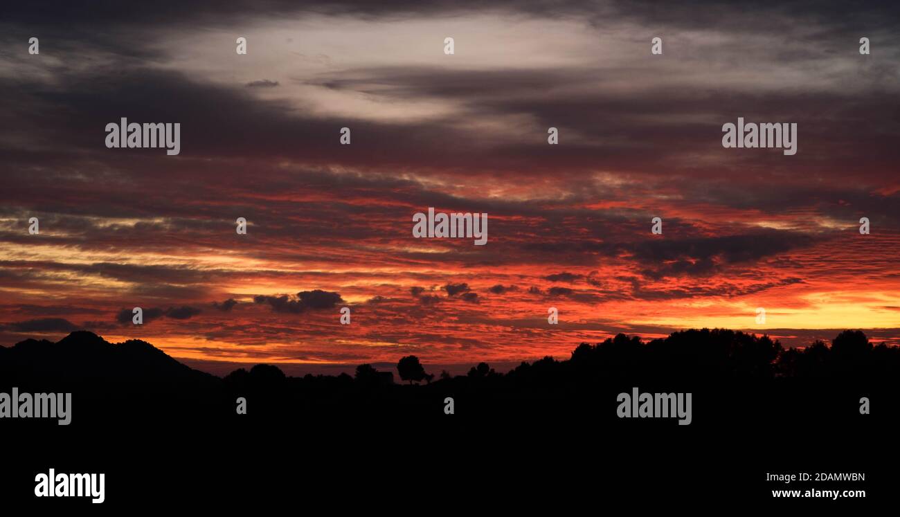 Hills and treeline silhouette against amazing colorful sunset sky Stock ...