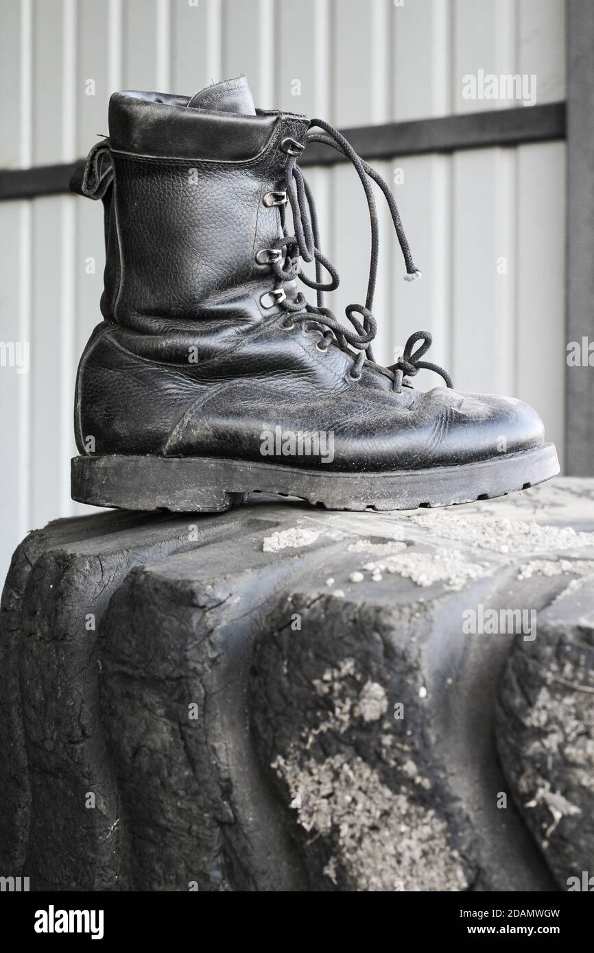 Old, discarded, right, black, leather, military boot, in the trash ...