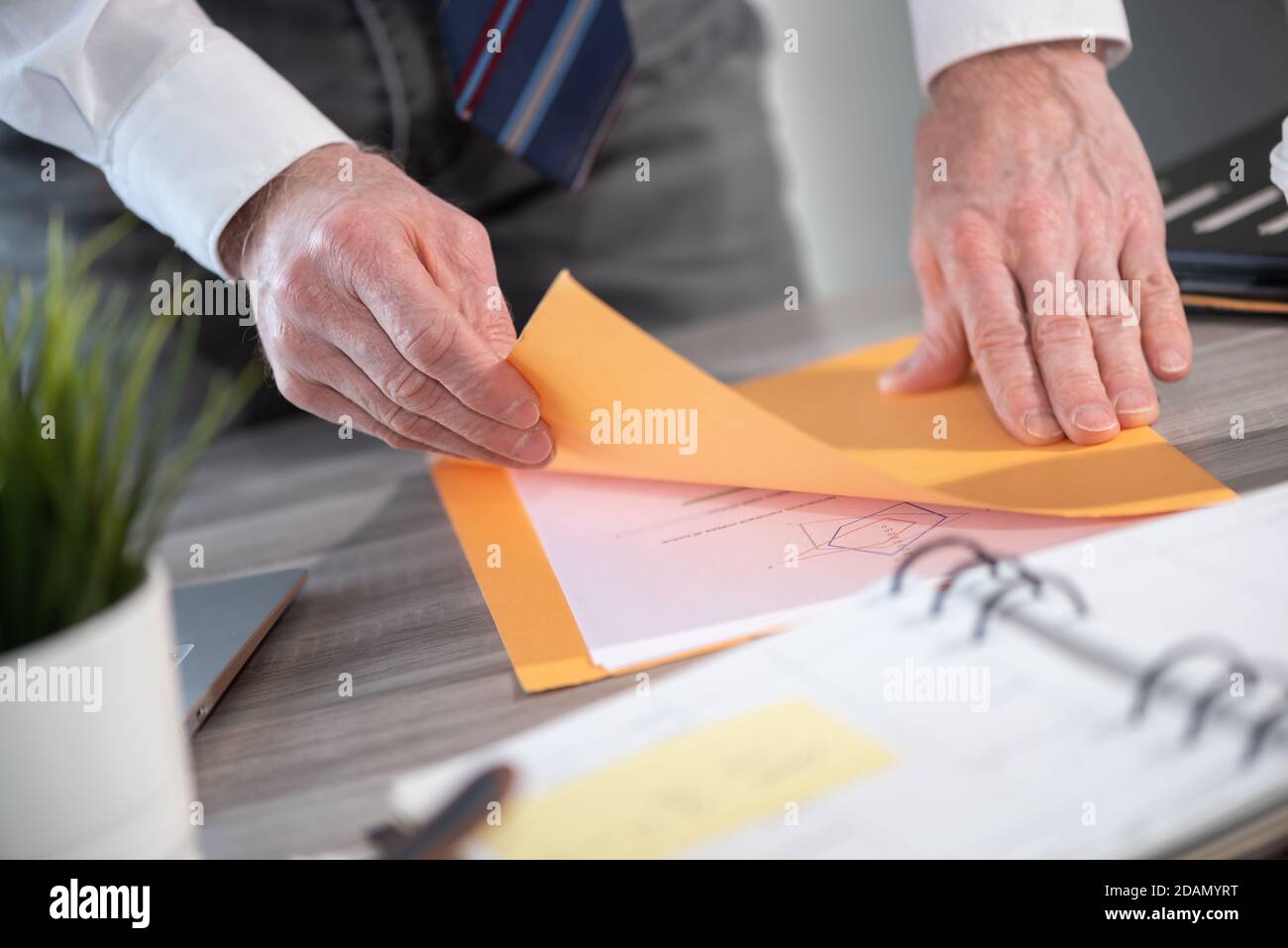 Businessman opening folder with paper documents Stock Photo - Alamy