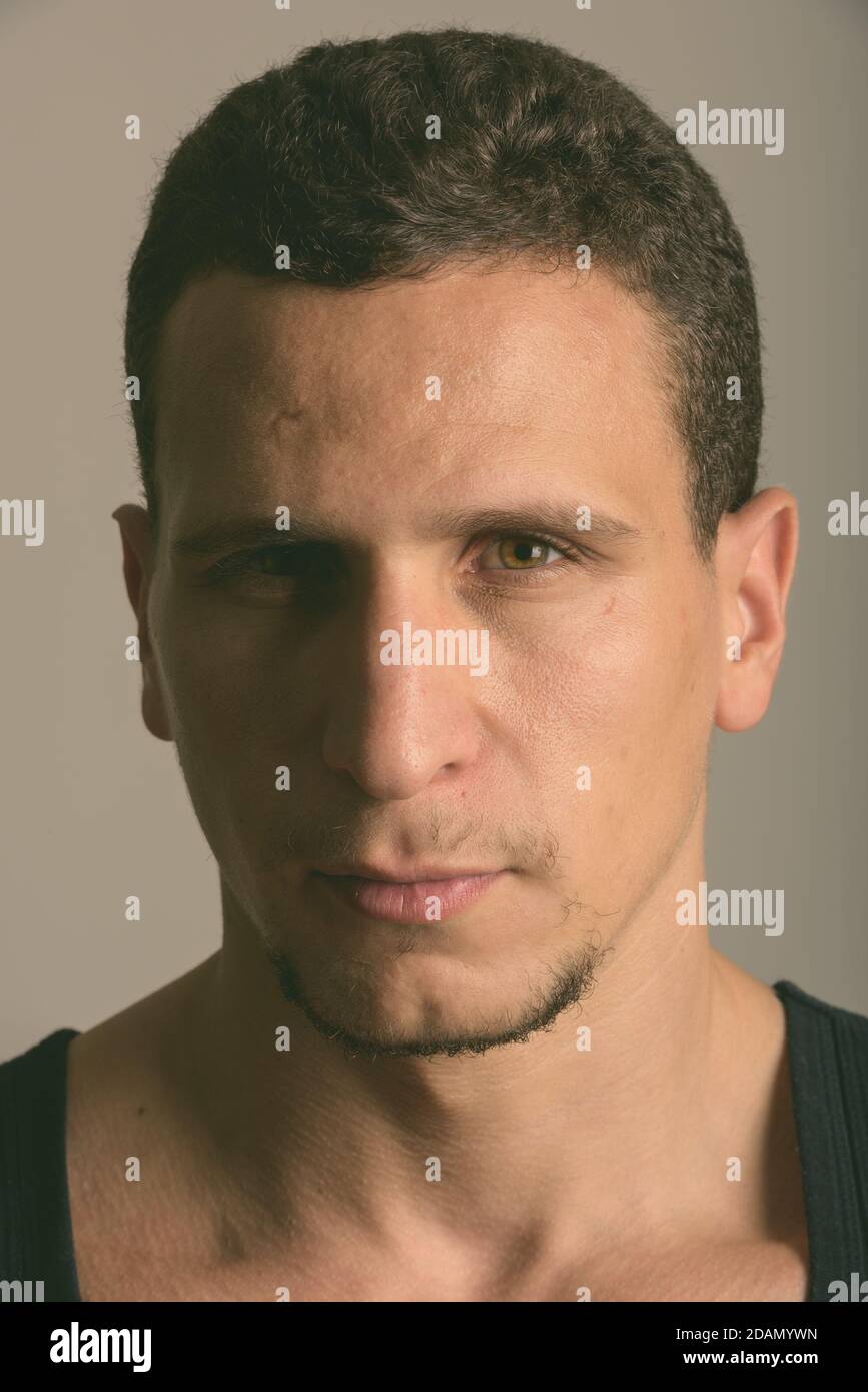 Face of young muscular Persian man against gray background Stock Photo ...