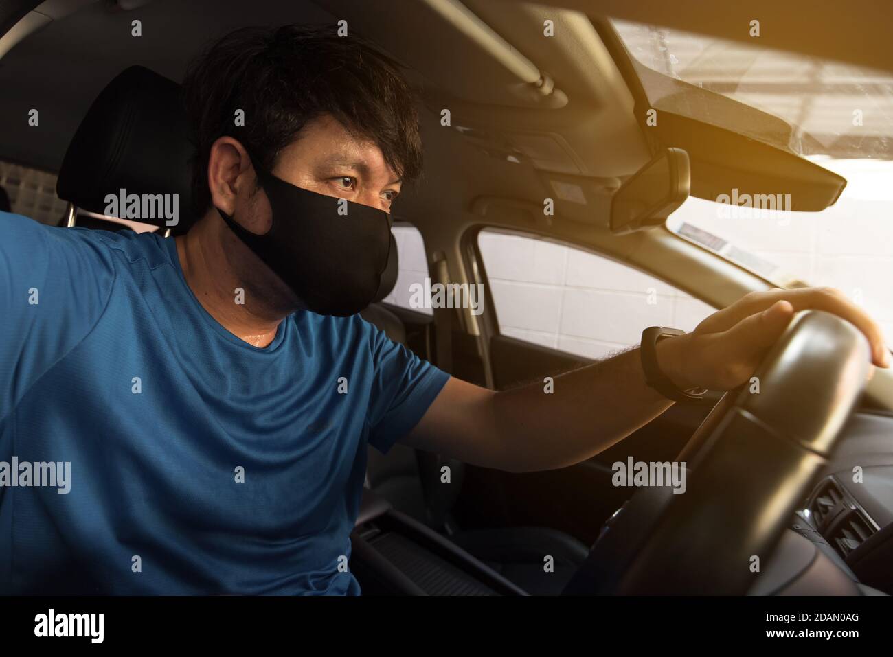 Asian man wearing black protection face mask sitting on driver car seat ...