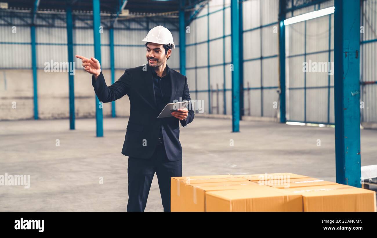 Factory manager using tablet computer in warehouse or factory ...