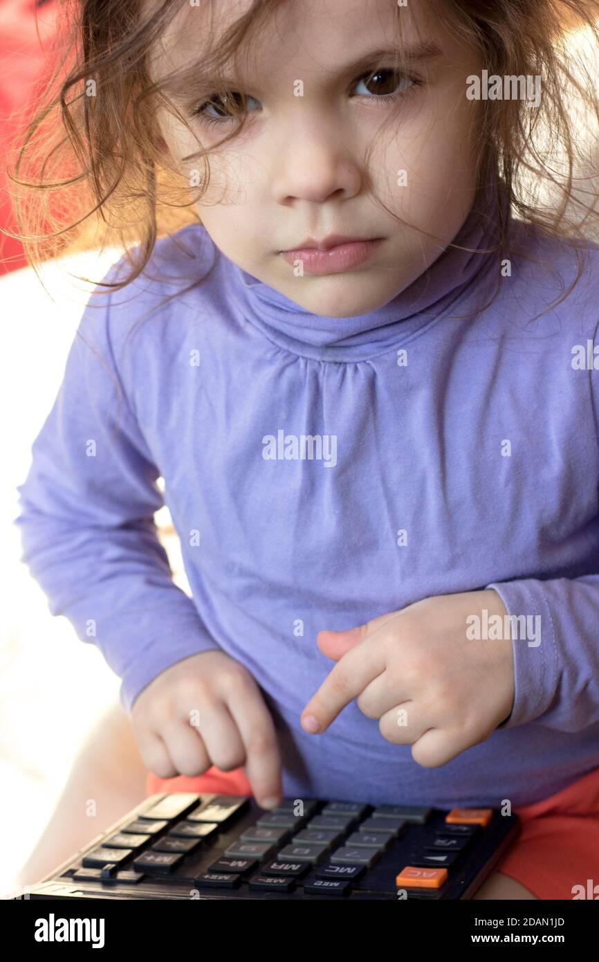 Little kid girl with a calculator in hands Stock Photo - Alamy