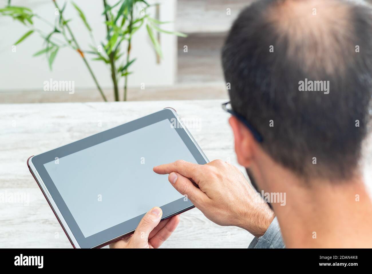 Man from behind using tablet Stock Photo - Alamy