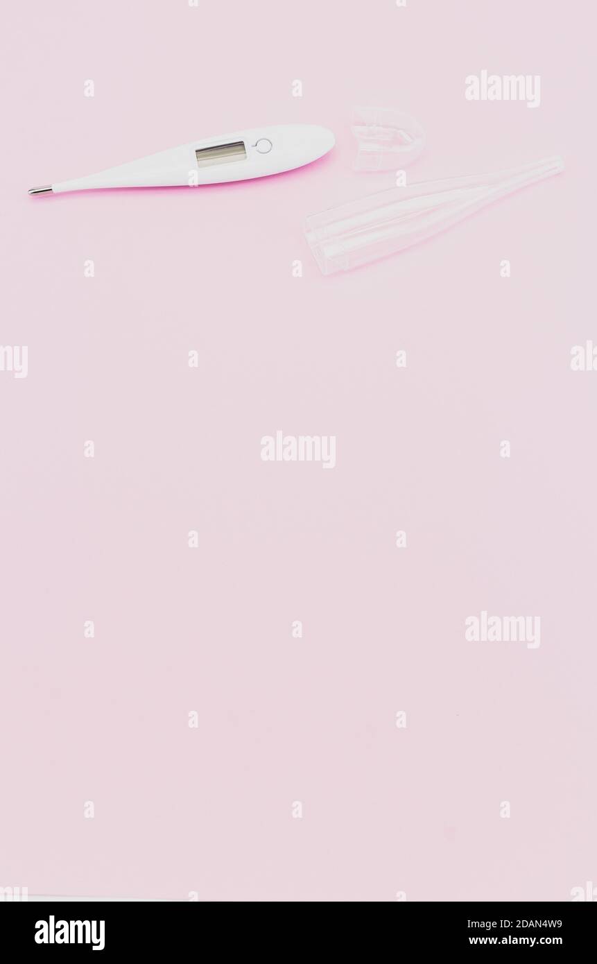 Vertical shot of digital thermometer on pink background with space for ...