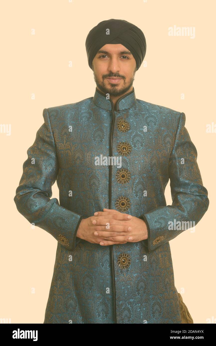 Young handsome Indian Sikh man intertwining fingers together wearing ...