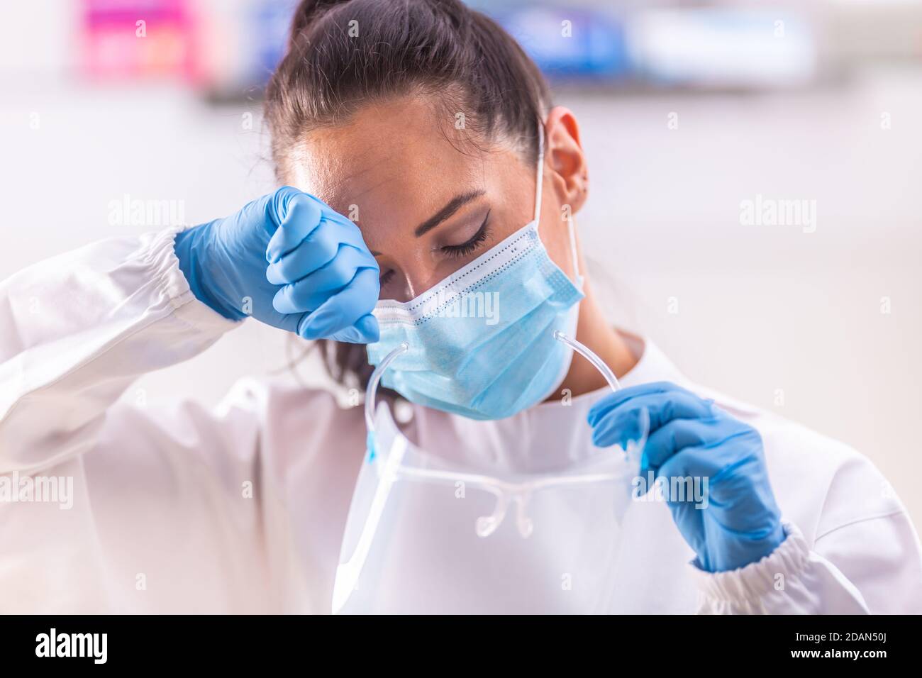 Exhaustion of medical staff worker wiping out sweat from forehead ...