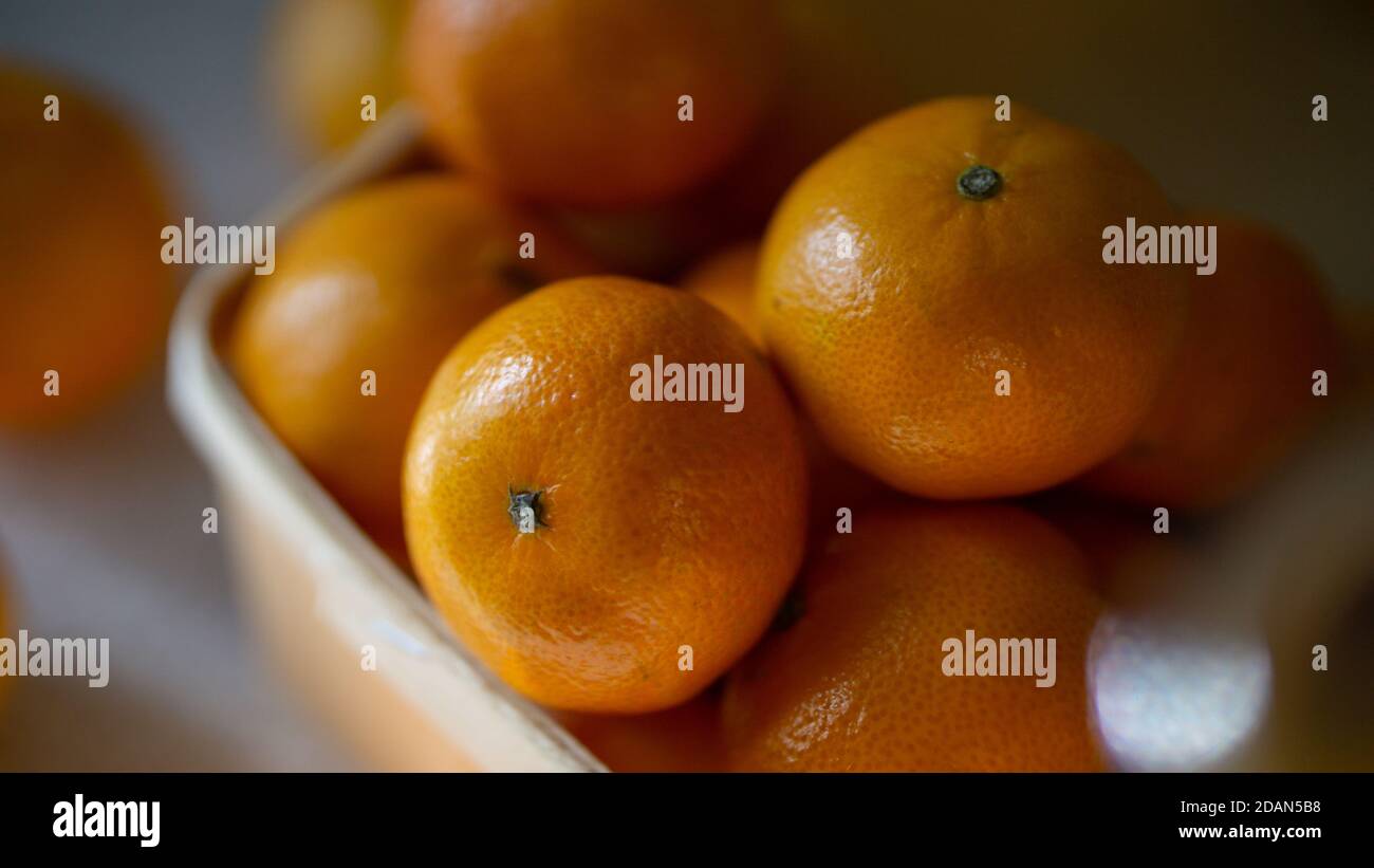 Close up of freshly harvested orange clementines in the basket ...
