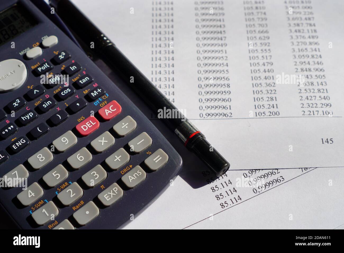 High angle shot of a calculator and a pen on a numbers sheet Stock ...