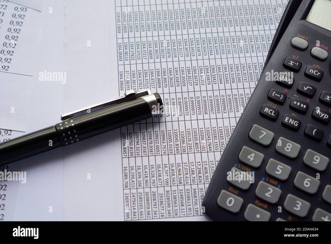 High angle shot of a calculator and a pen on a numbers sheet Stock ...