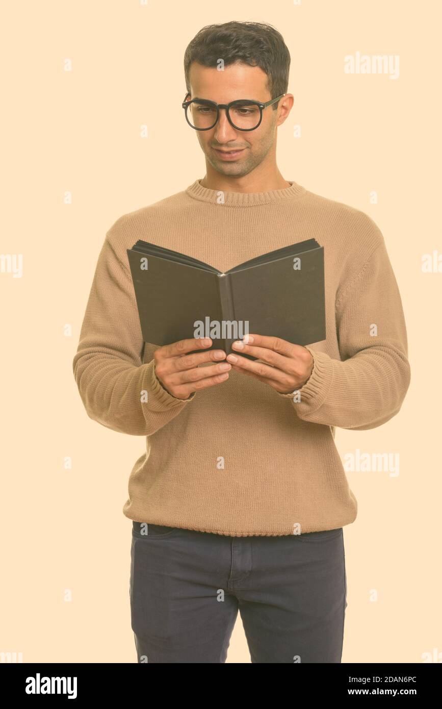 Young happy Iranian man smiling and reading book Stock Photo - Alamy