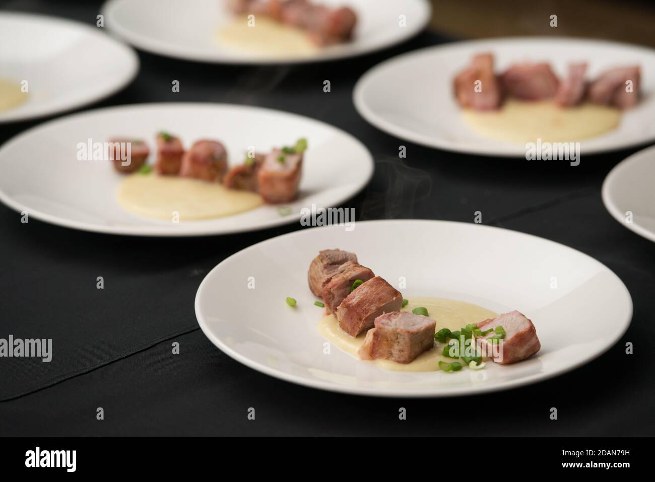 Closeup of chief serving delicious roasted pork meat wrapped in bacon ...