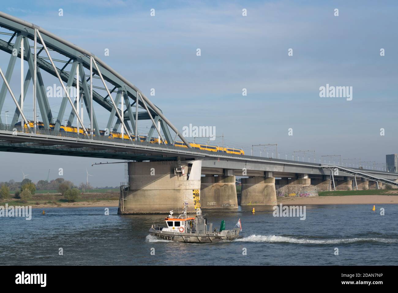 Dutch passenger train passing a blue bridge in Nijmegen, Gelderland ...